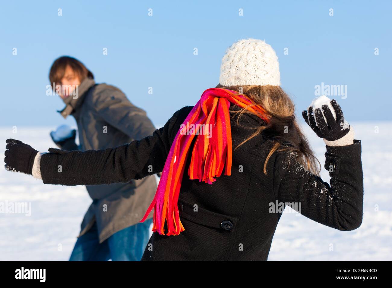 Couple - man and woman - having a snowball fight in winter Stock Photo ...