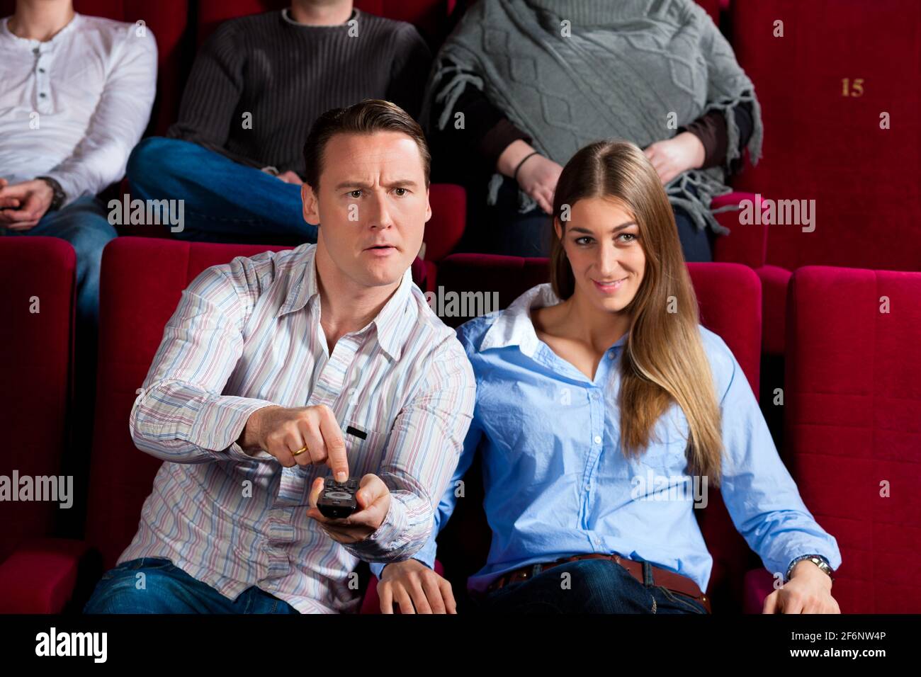 Couple and other people, probably friends, in cinema watching a movie ...