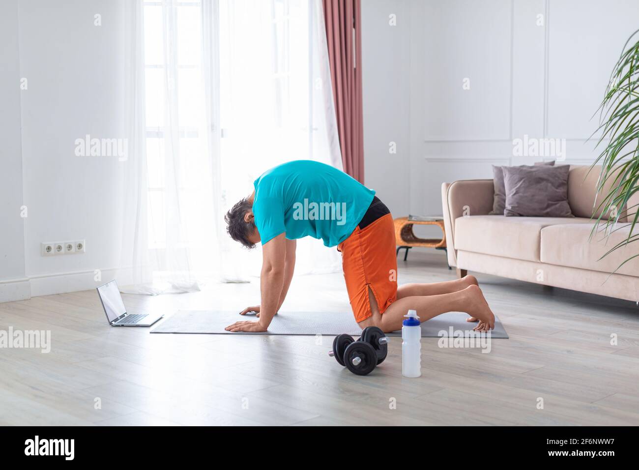 Home workout and healthy lifestyle concept - middle-aged man during ...