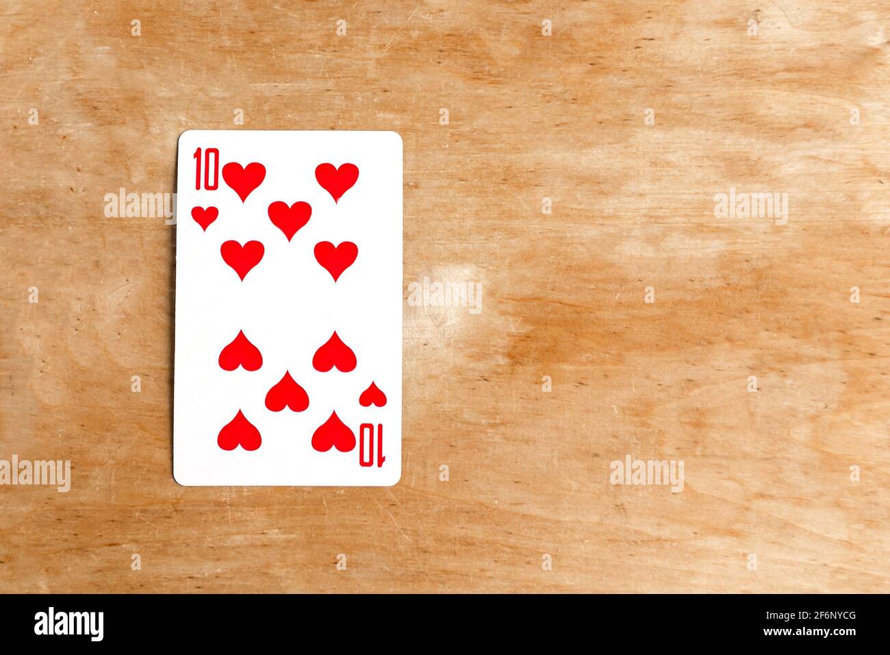 Ten of Hearts playing card, wooden background. Copy space Stock Photo ...