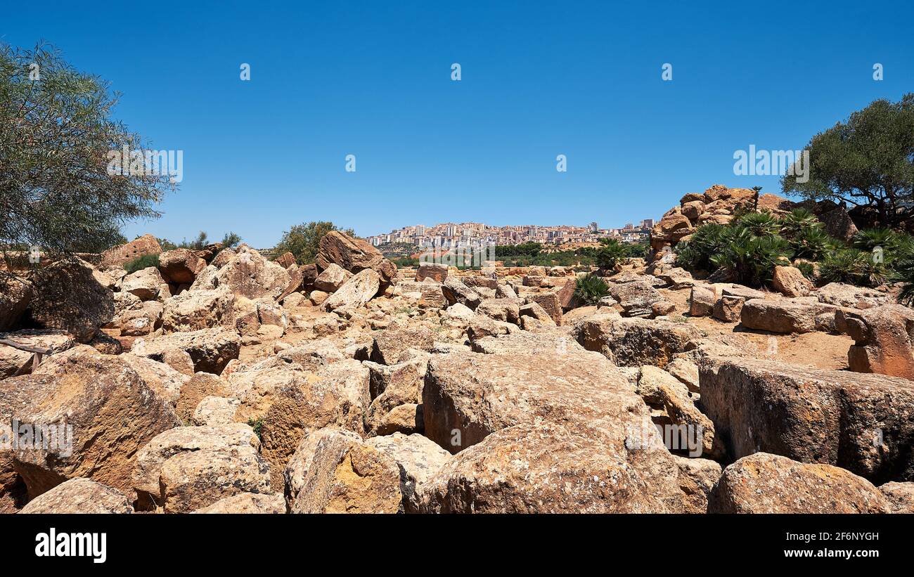 Ancient stones and broken columns. Landscape with olive trees and view ...