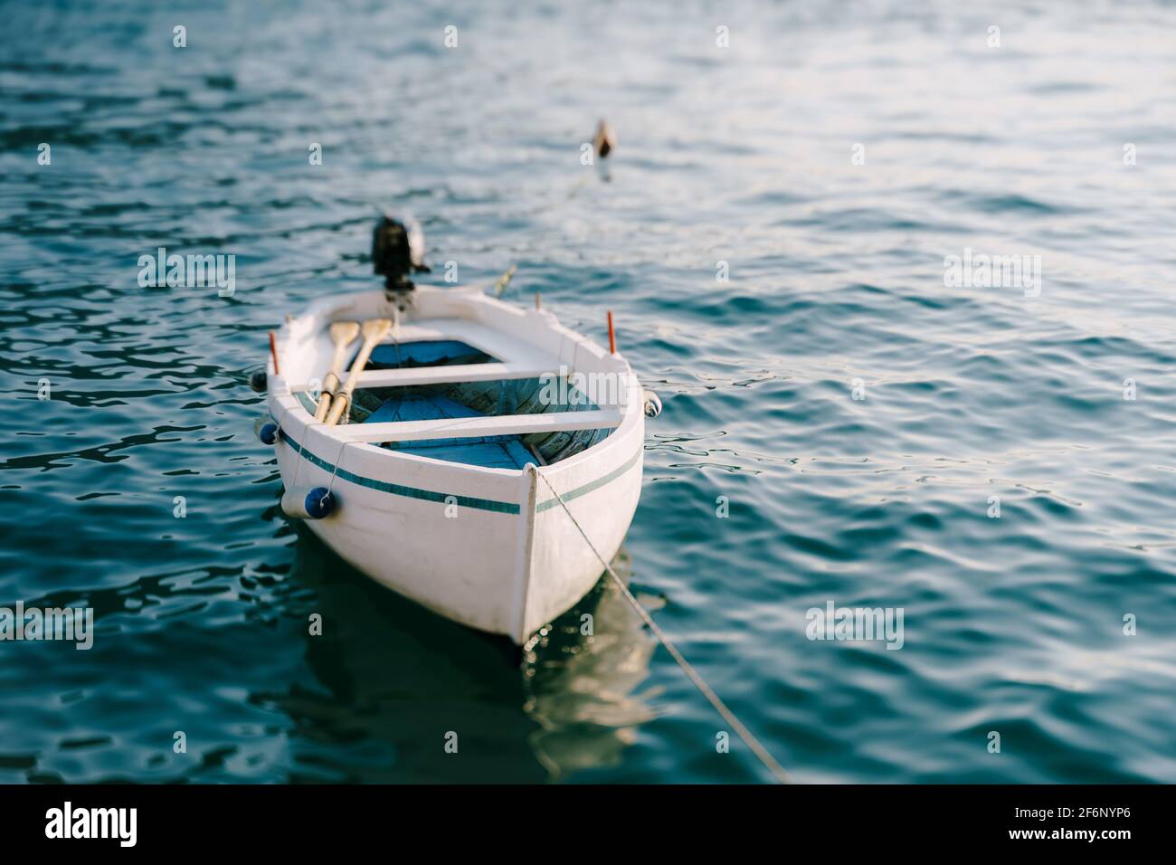 White wooden fishing boat with oars and motor Stock Photo - Alamy