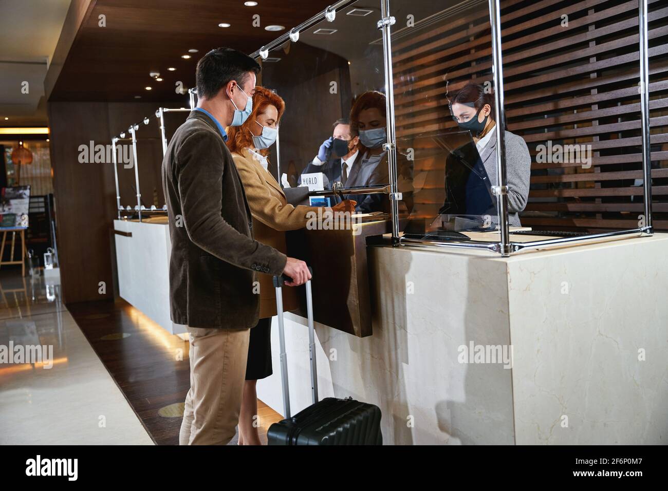 Guests filling in the registration form at the reception desk Stock ...