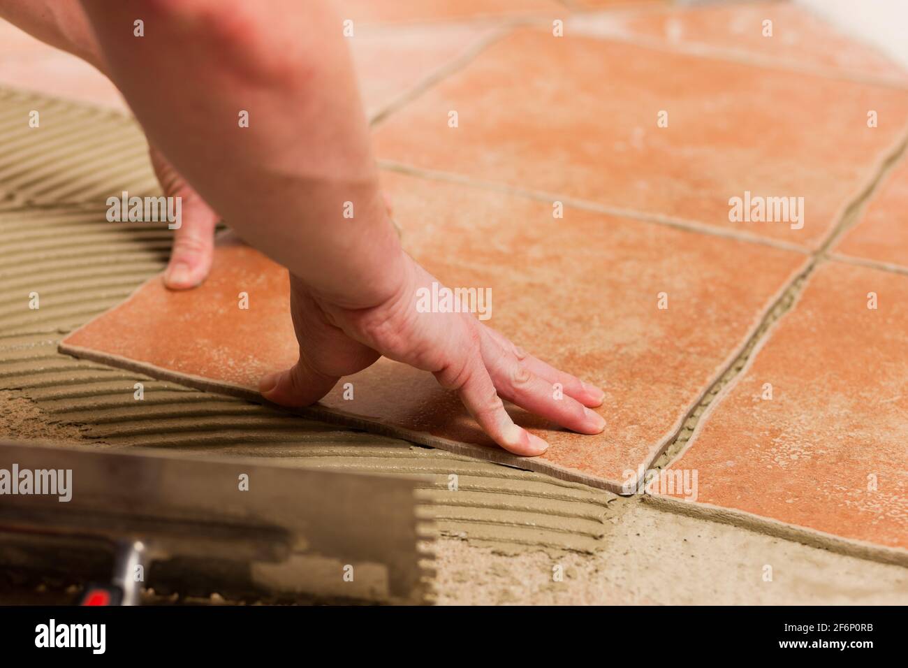Construction worker is tiling at home Stock Photo - Alamy