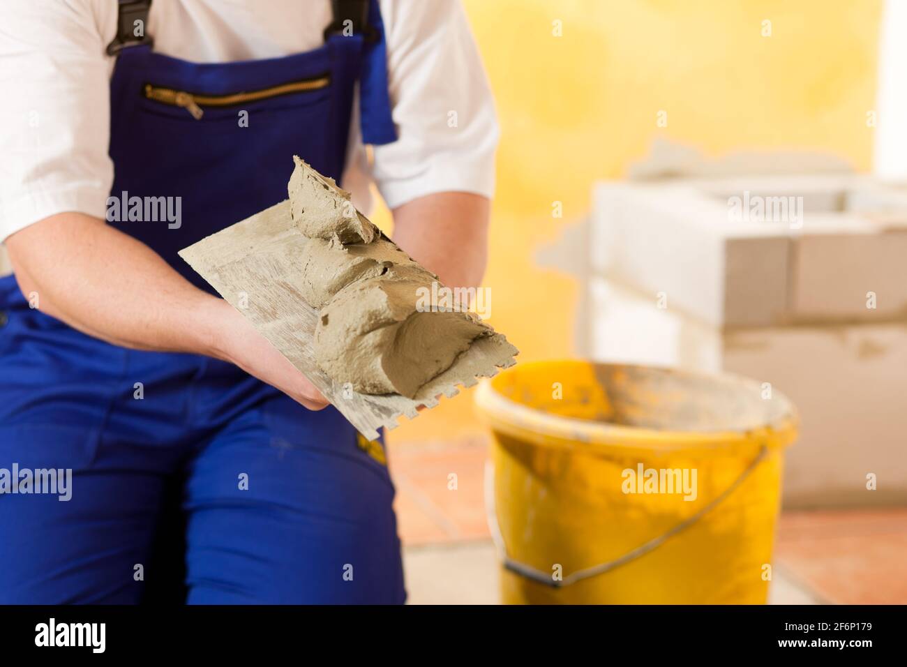 Construction worker is tiling at home Stock Photo - Alamy