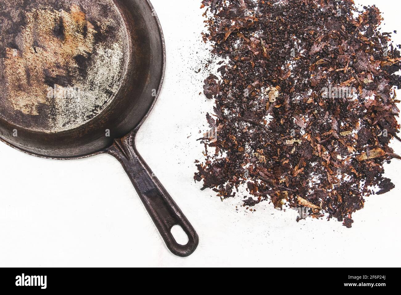 Old skillet. A pile of rusty, dirty soot from the bottom of the pan on ...