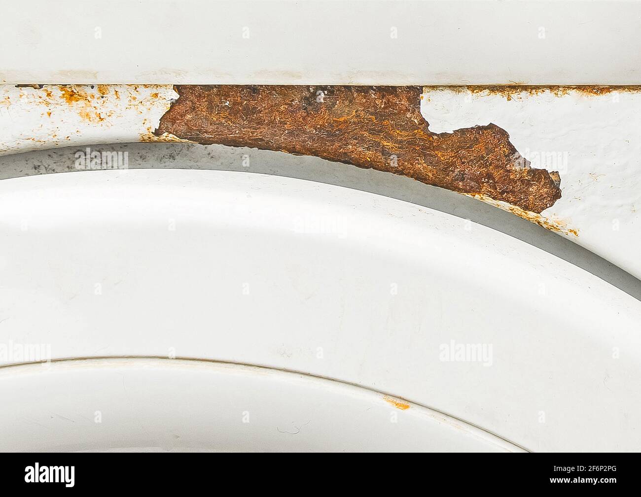 Element of an old white washing machine with a trace of rust close-up ...