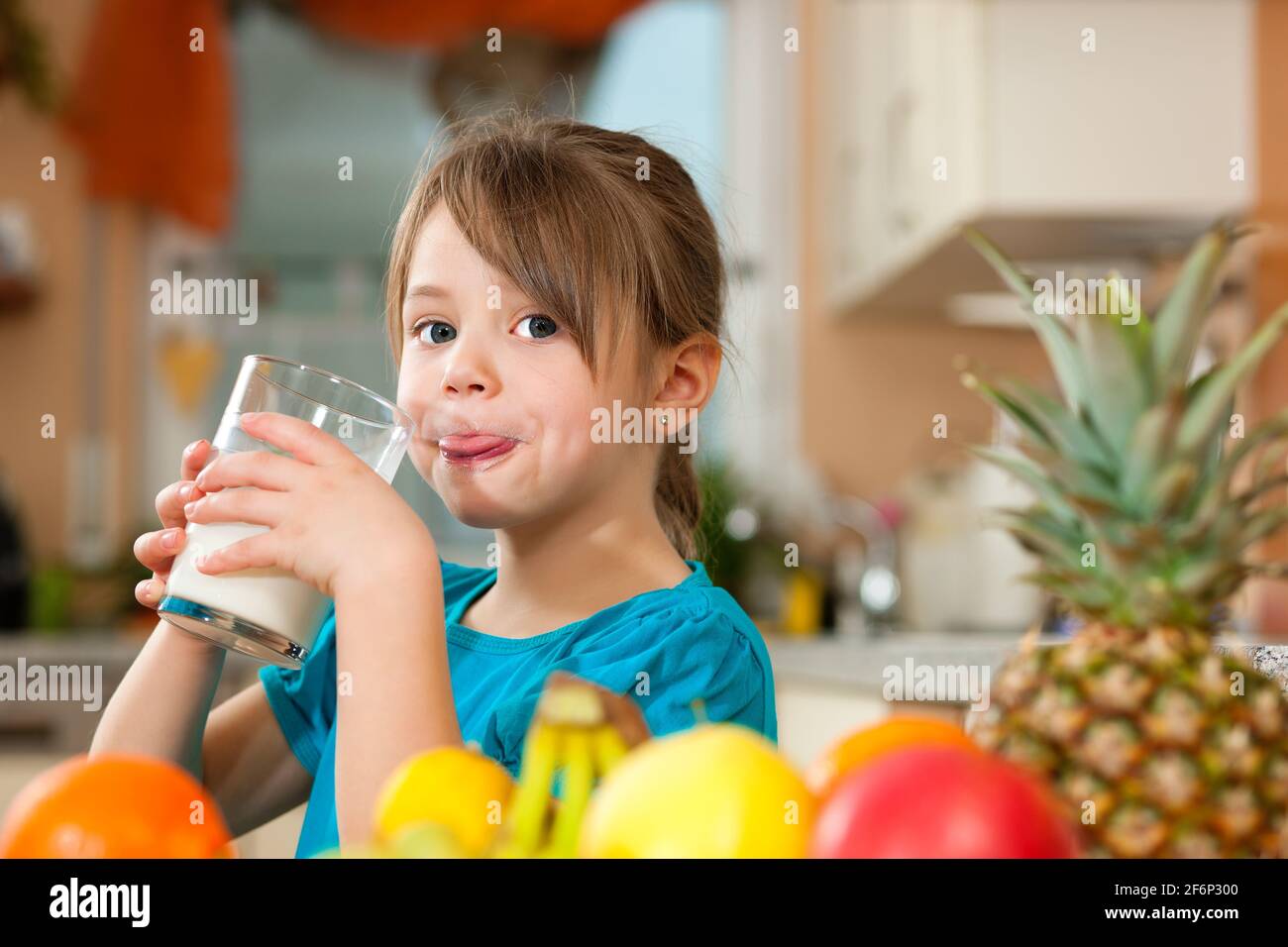 Healthy eating - Child drinking milk, lots of fresh fruit on the table ...