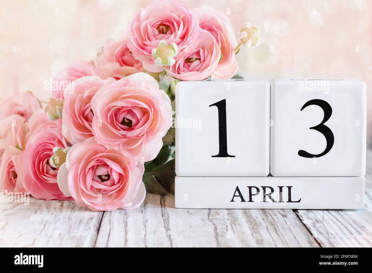 White wood calendar blocks with the date April 13th. Selective focus ...