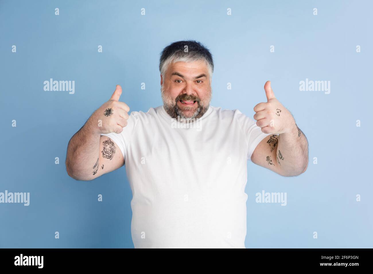 Handsome caucasian plus size male model isolated on blue studio ...