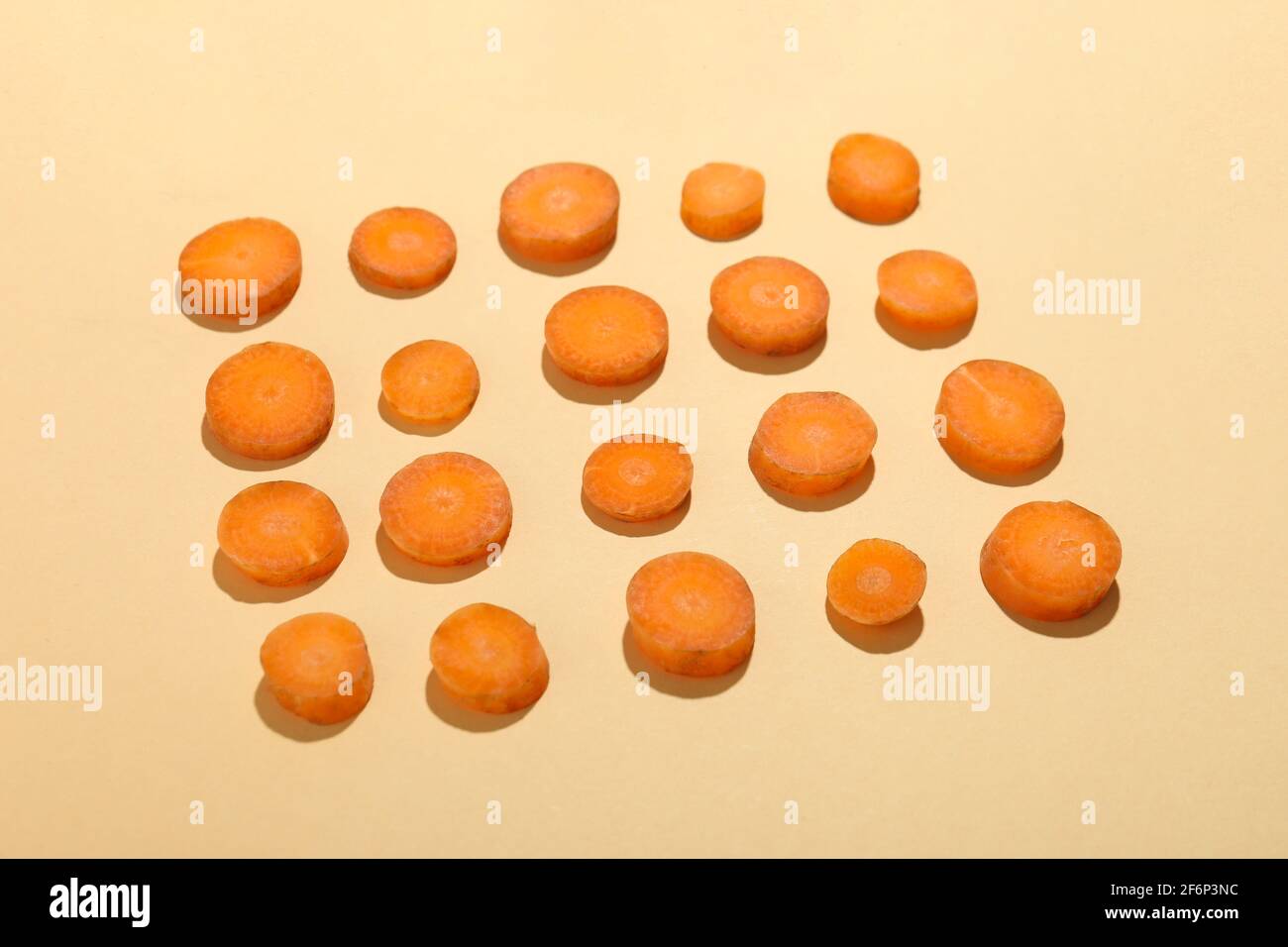Slices of fresh carrot on beige background Stock Photo - Alamy