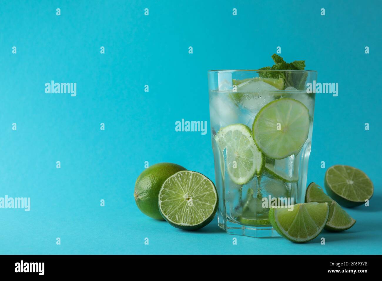 Glass of mojito cocktail and ingredients on blue background Stock Photo ...
