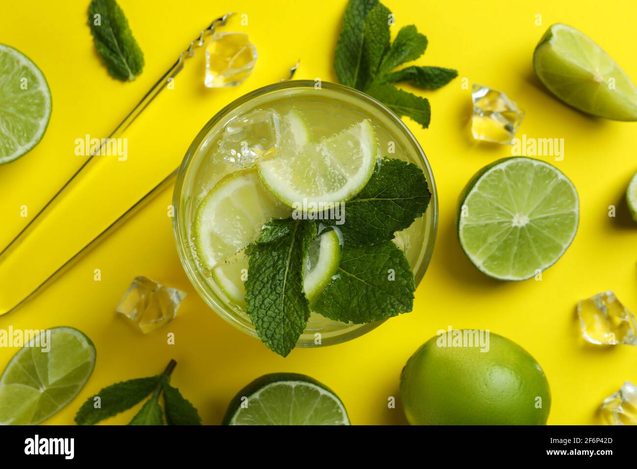 Glass of mojito cocktail and ingredients on yellow background Stock ...