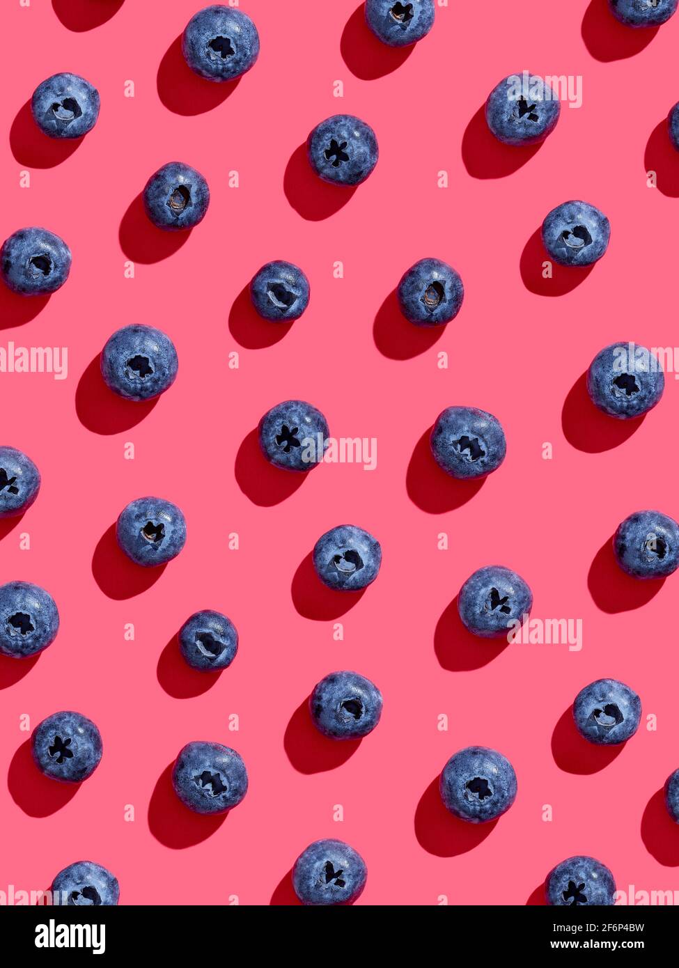 Vertical colorful blueberry pattern on pink background, from above ...
