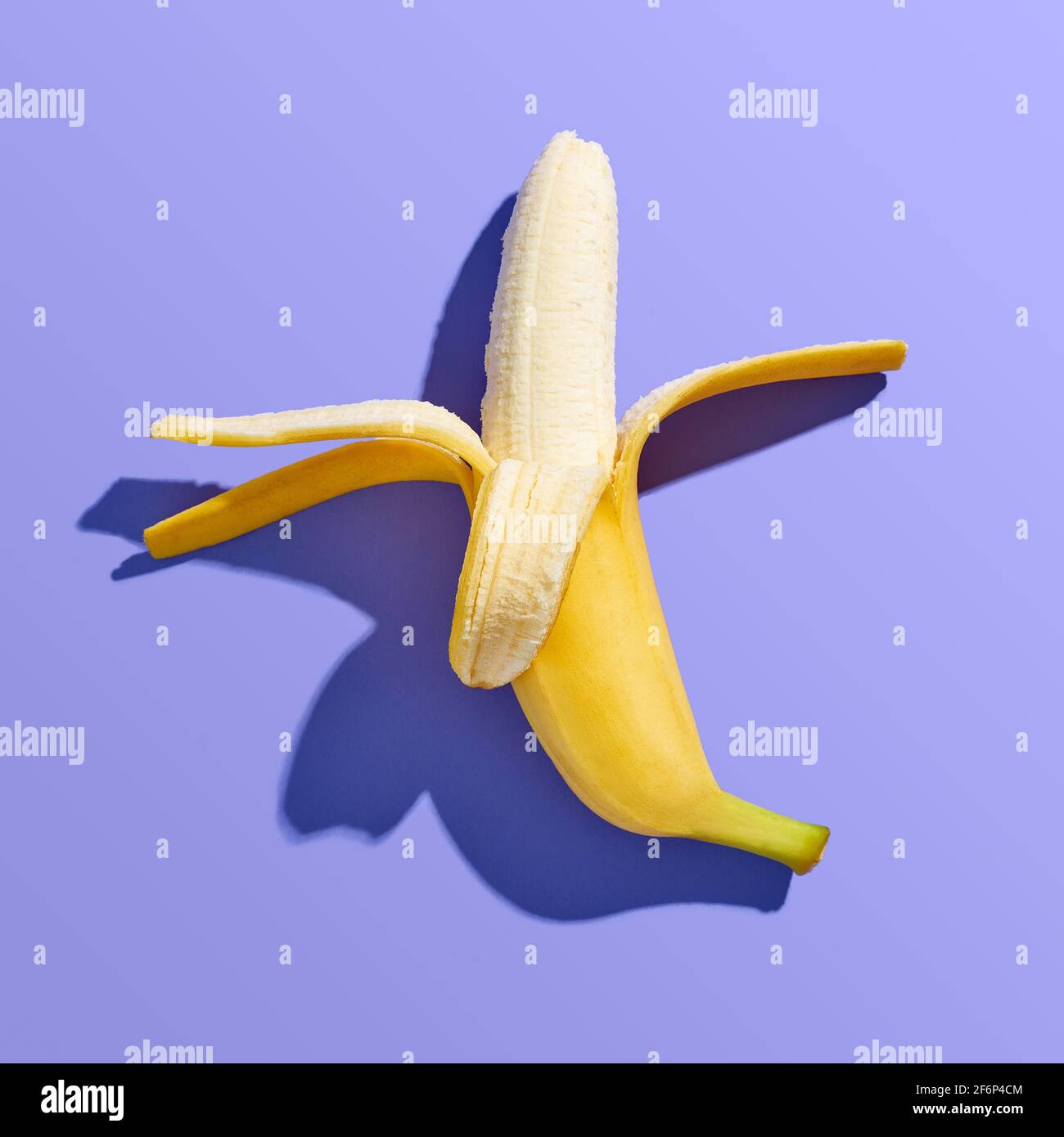 Peeled banana on violet background, from above, hard shadow Stock Photo ...