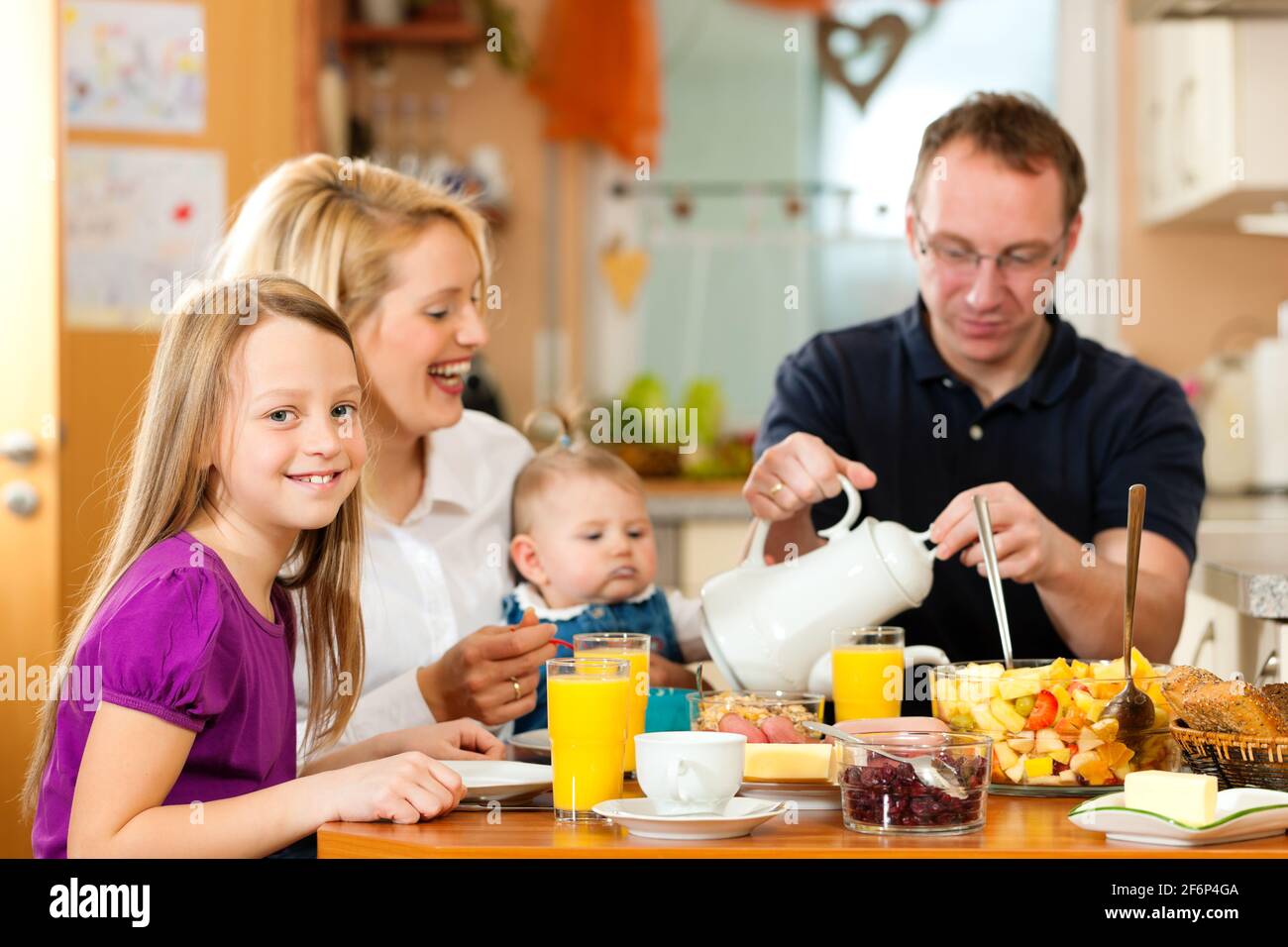 Family eating breakfast in the kitchen of their house Stock Photo - Alamy
