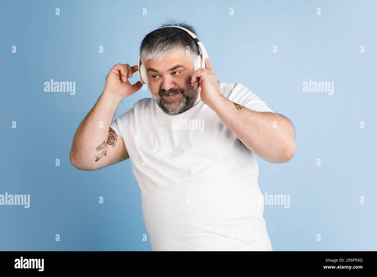 Handsome caucasian plus size male model isolated on blue studio ...