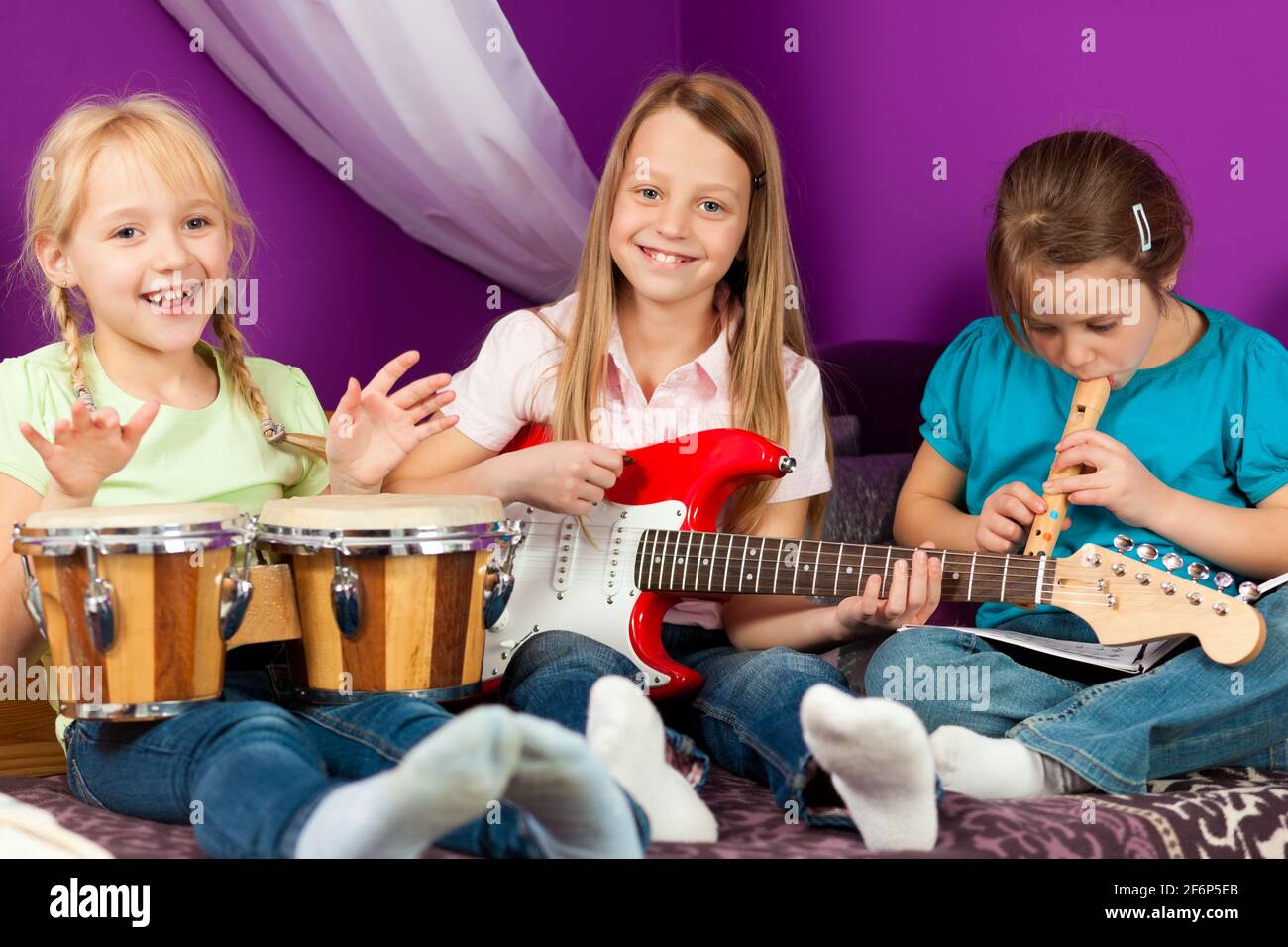 Children - sisters - making music, they are practicing playing guitar ...