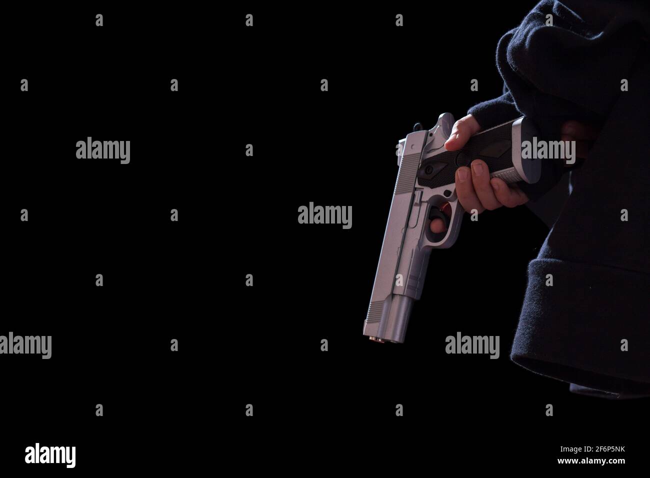 Little boy with a gun behind my back on black background with copy ...