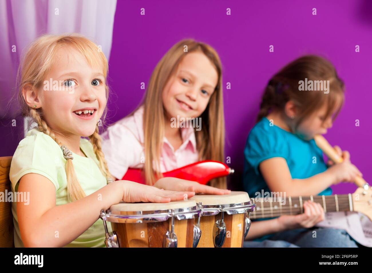 Children - sisters - making music at home, they are practicing playing ...