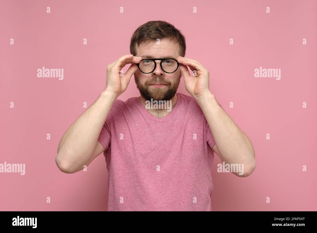 Caucasian man with poor eyesight trying on glasses, he thoughtfully ...
