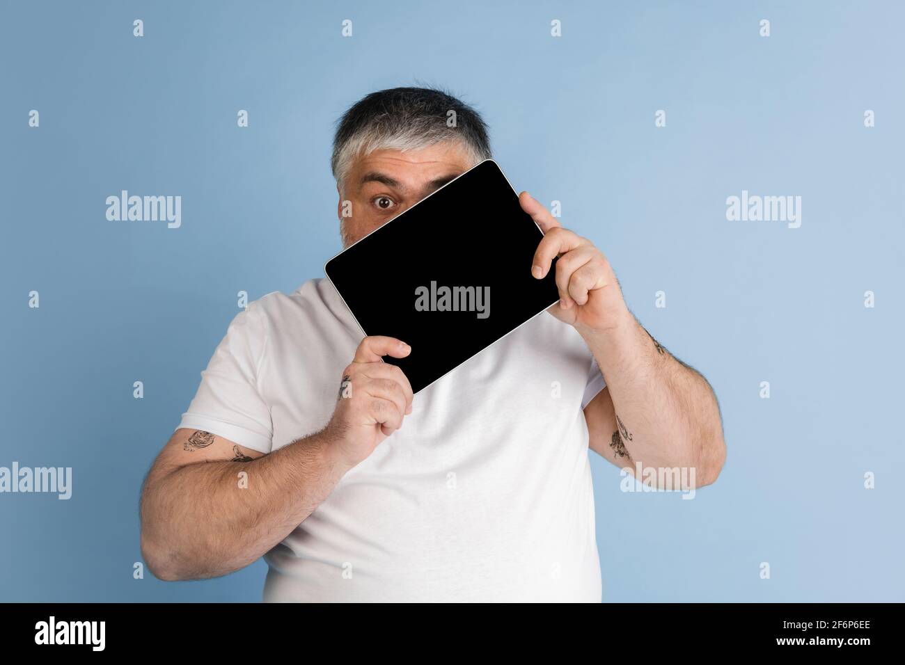 Handsome caucasian plus size male model isolated on blue studio ...
