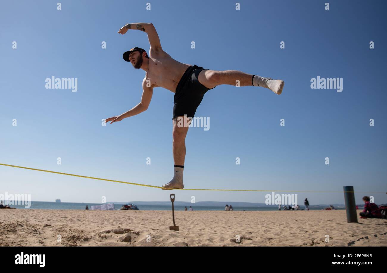 A slackliner practices on boscombe beach hi-res stock photography and ...