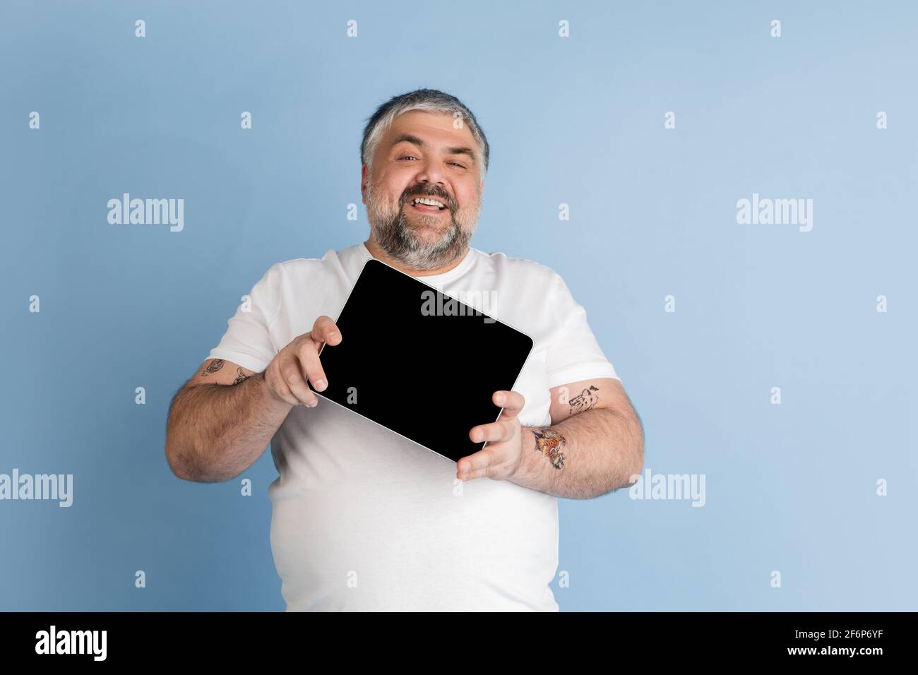 Handsome caucasian plus size male model isolated on blue studio ...