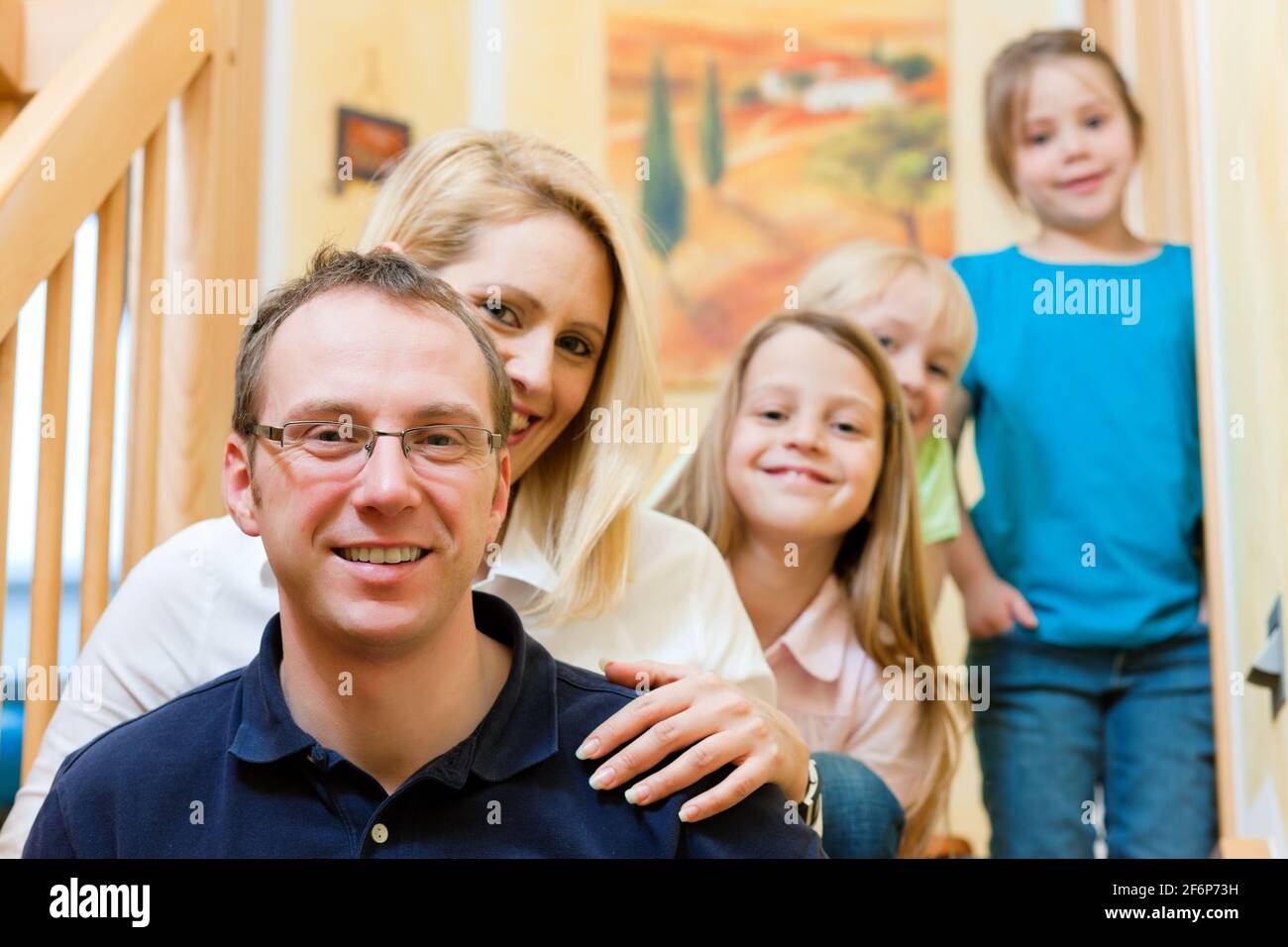 Happy family with three children at home on stair Stock Photo - Alamy