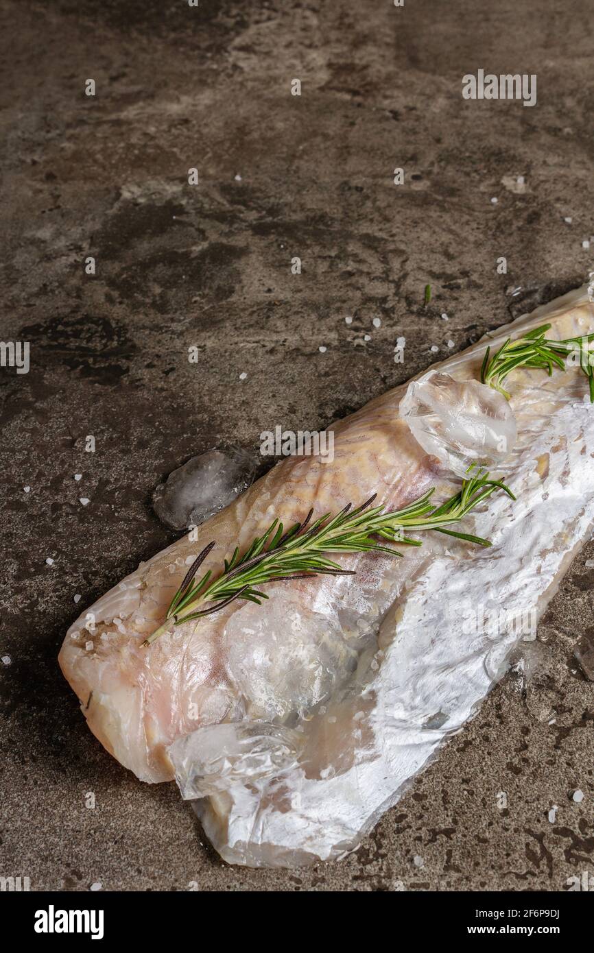 Raw frozen hake fillet with ice and fresh rosemary. Healthy food ...