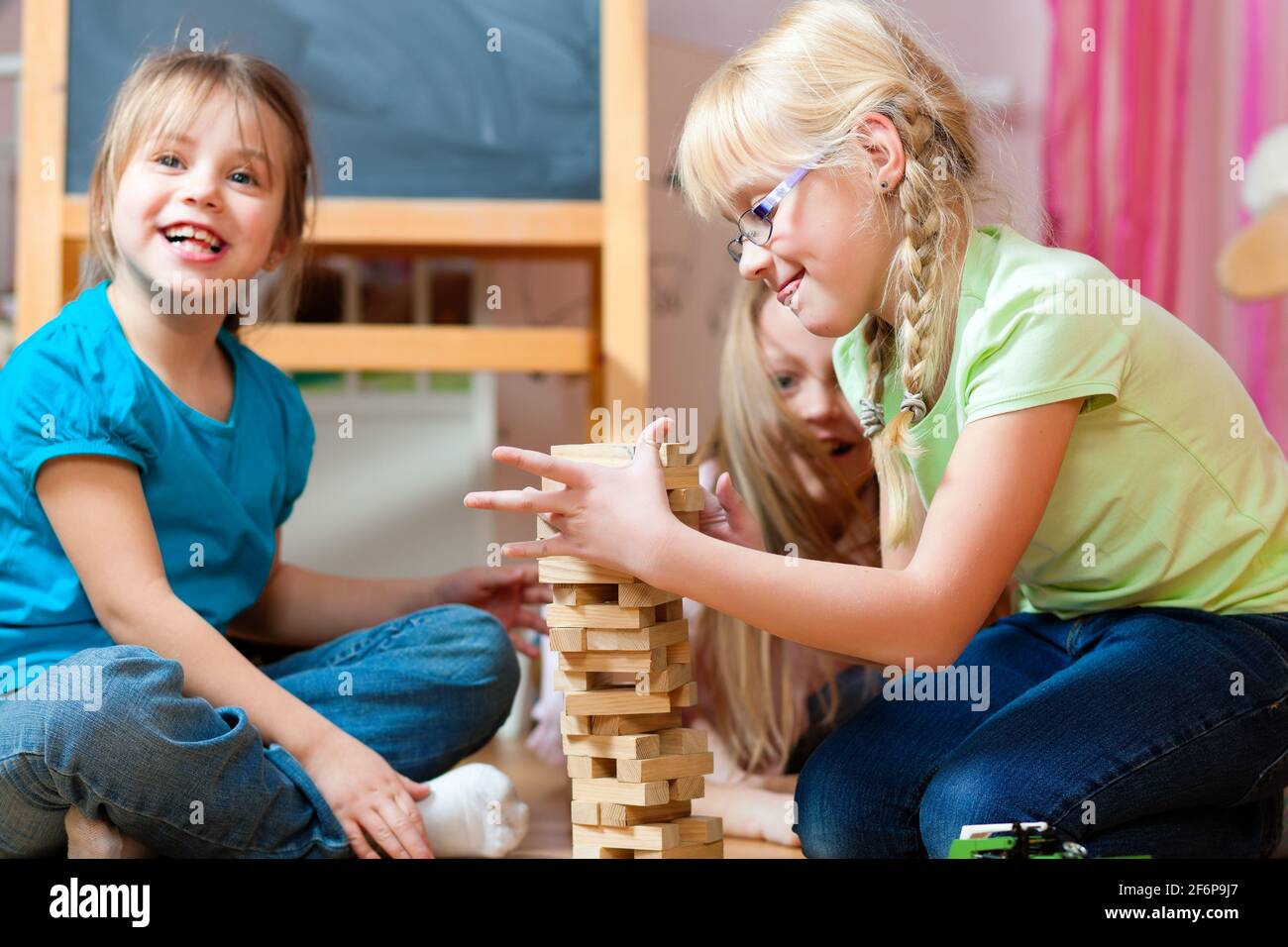 Children - sisters - playing at home with bricks Stock Photo - Alamy