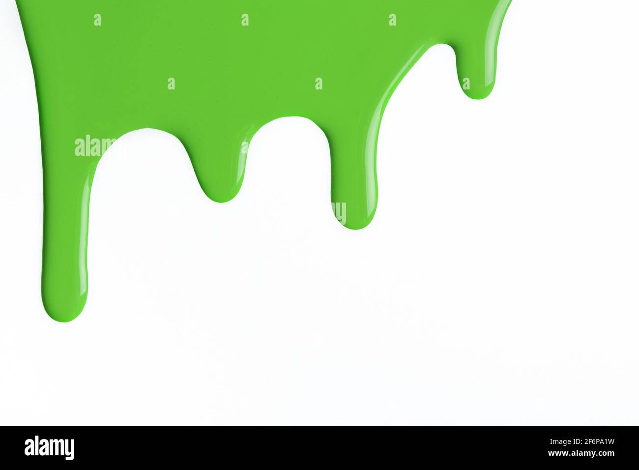 Light green liquid drops of paint color flow down on isolated white ...