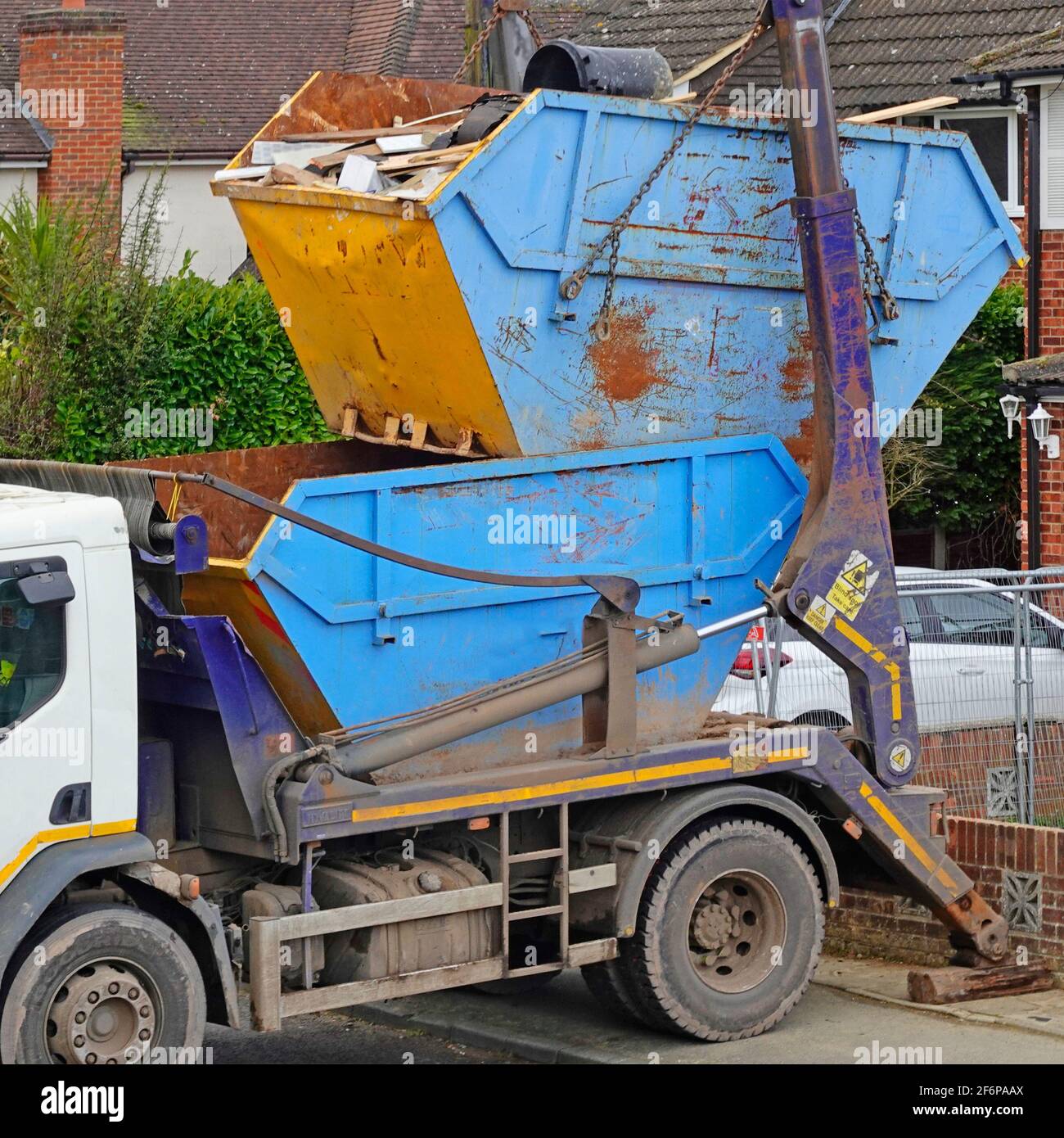 Full heavy rubbish bin lifted from compact building construction site ...