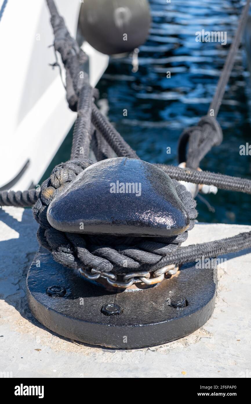 Mooring bollard concept. Ropes twisted with knobs on black metal steel ...