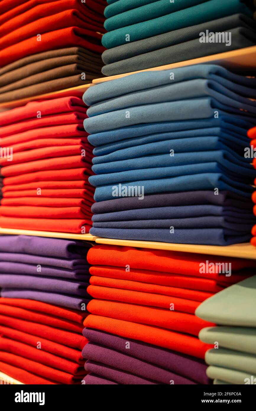 Vertical photo of multicolored pieces of clothes folded in a shelve and ...