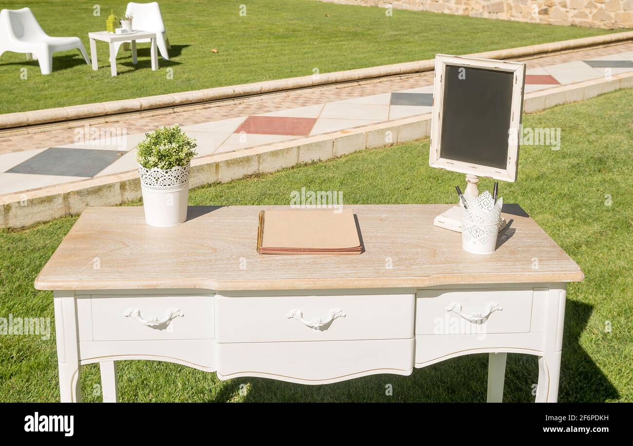 Signature book and small blackboard on an outdoor table in a garden ...