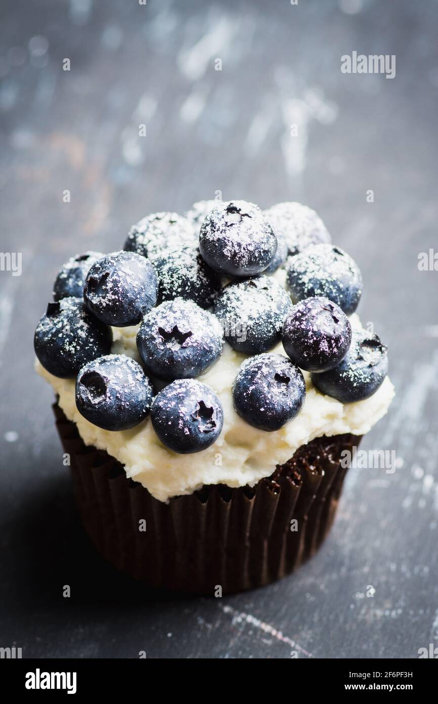 Homemade muffin with blueberry and cream cheese frosting on the rustic ...