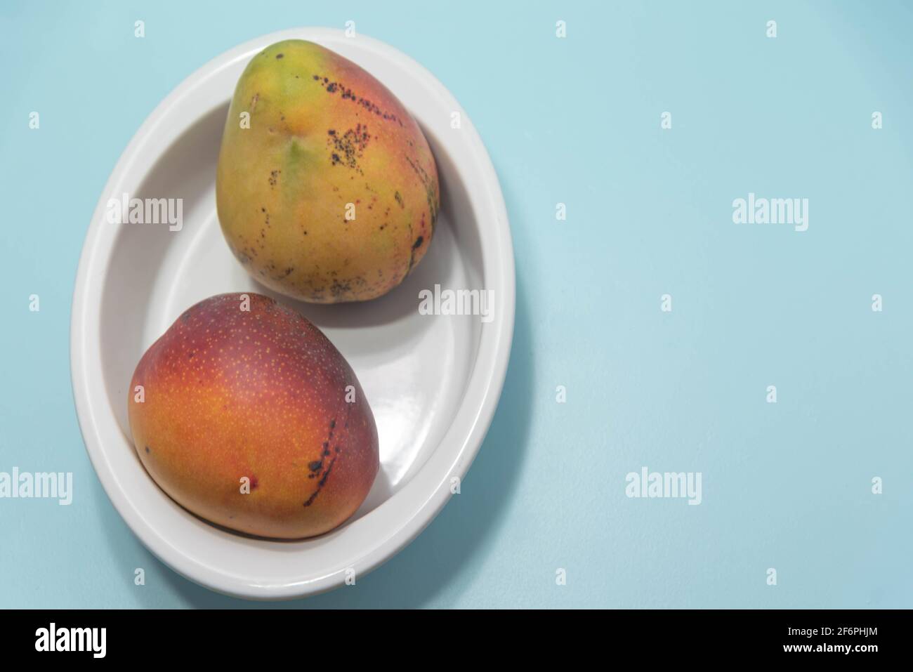 Fresh pink mango fruit on blue background. Fruit rich in fiber and ...