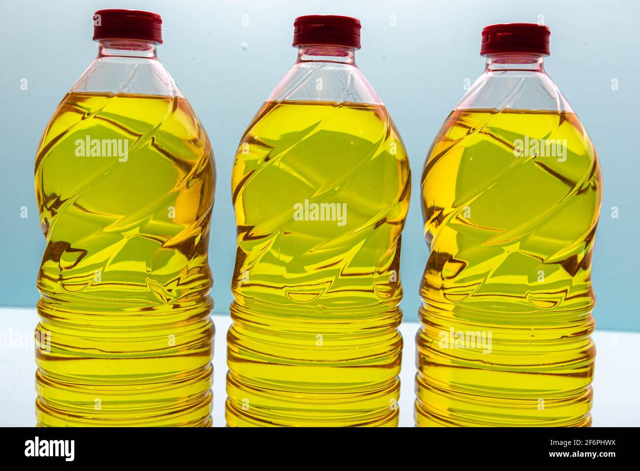 plastic bottles with edible soy oil on blue background. Vegetable oil ...