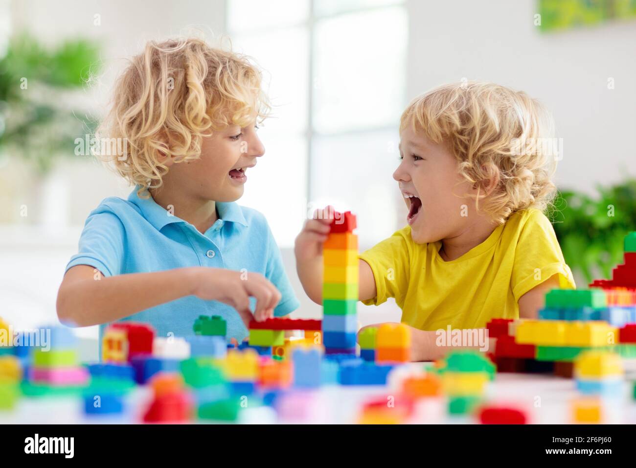Kids play with colorful blocks. Little boy building tower at home or ...