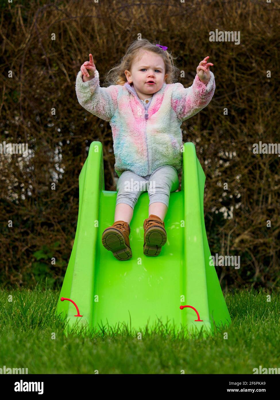 Toddler sat on a garden slide singing, UK Stock Photo - Alamy