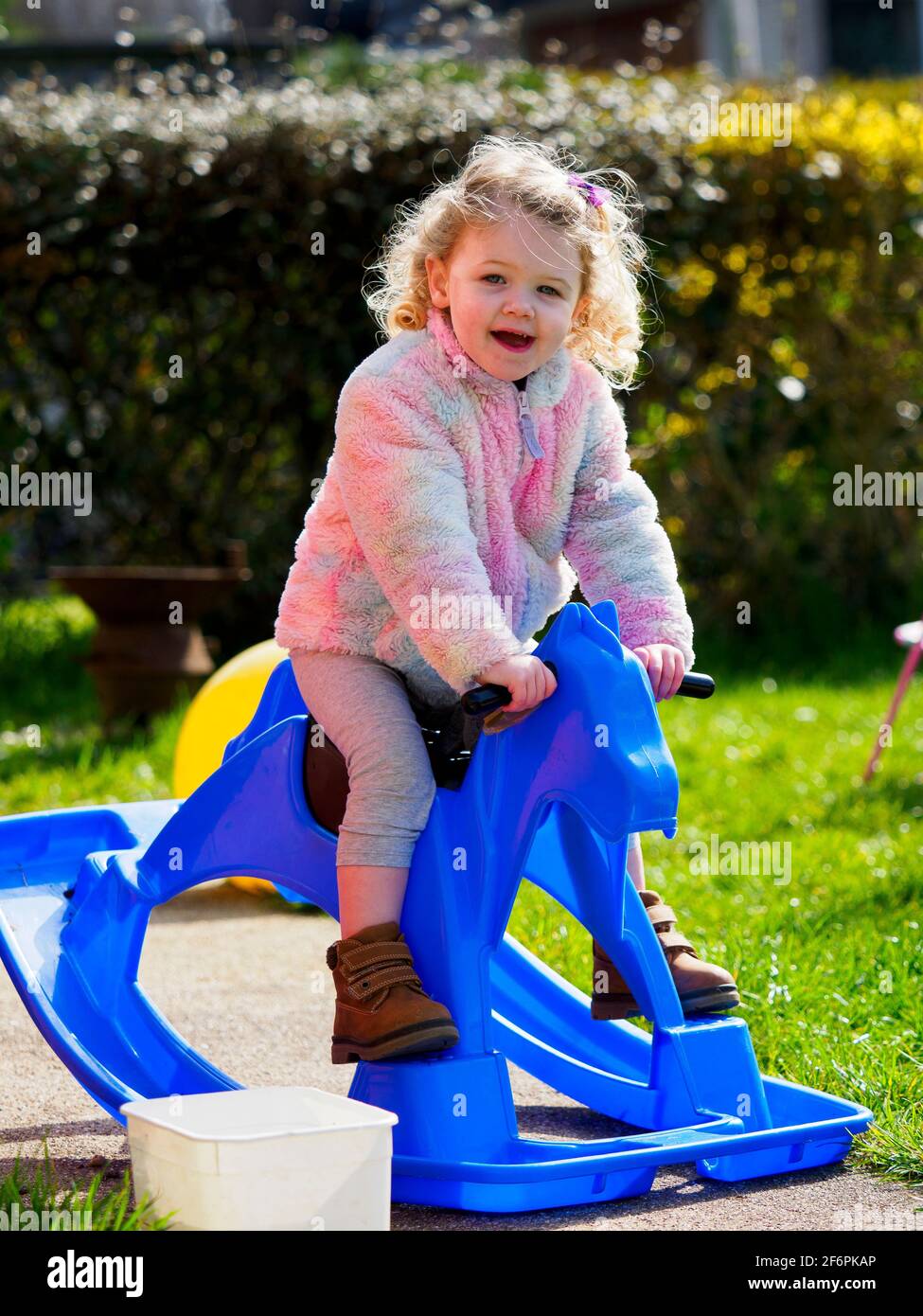 Toddler on a rocking horse in the garden, UK Stock Photo - Alamy