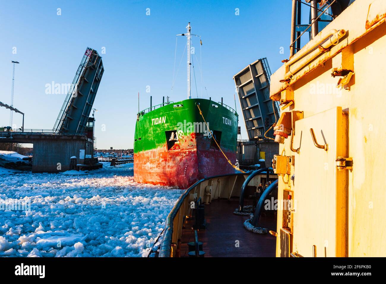 Tug boat pulling freight ship through open bridge Stock Photo - Alamy
