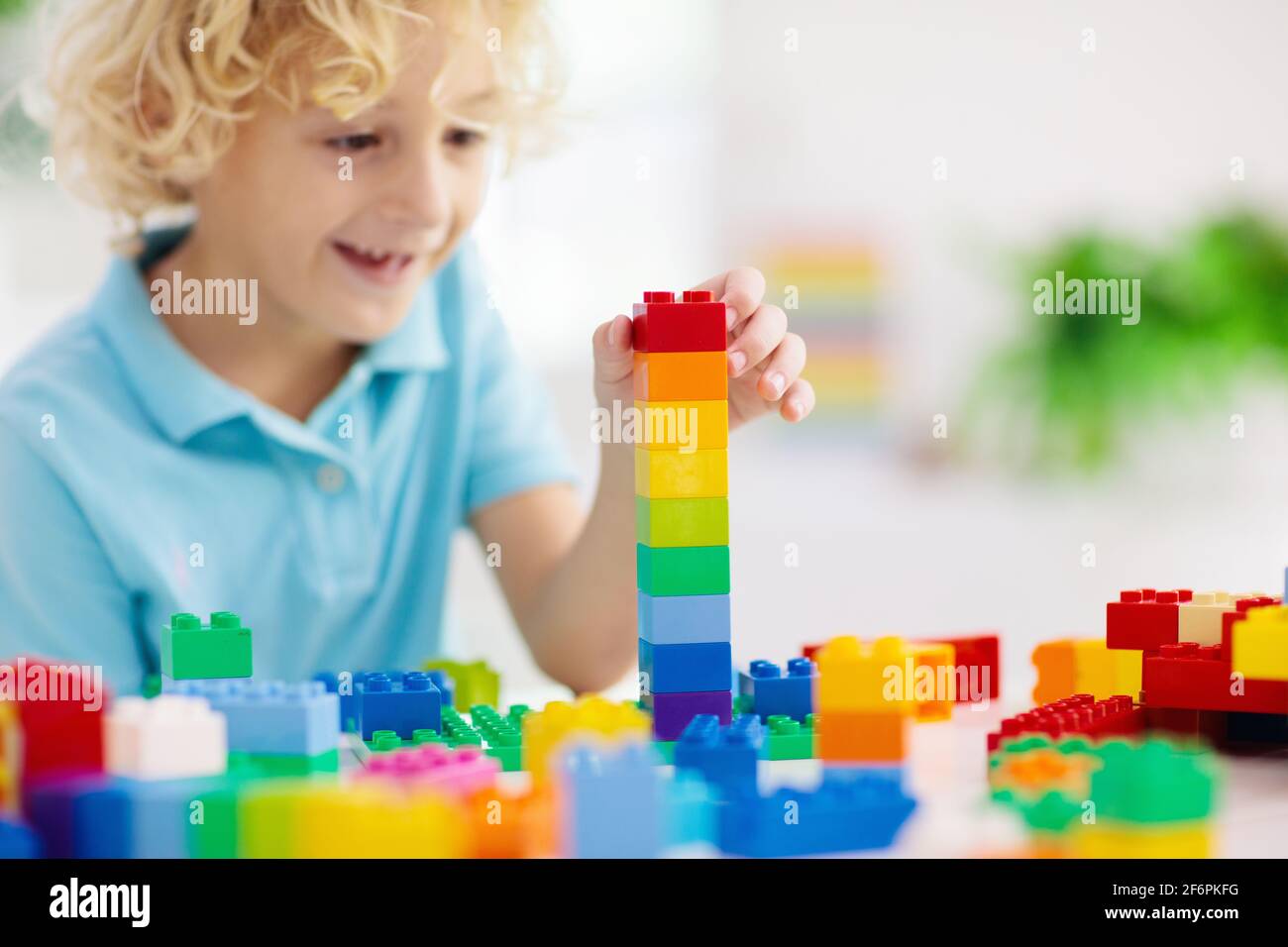 Kids play with colorful blocks. Little boy building tower at home or ...