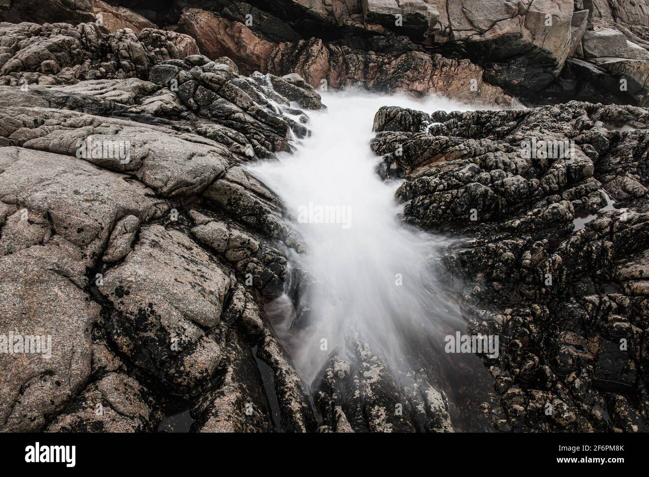 Water flowing on rocky beach Stock Photo - Alamy