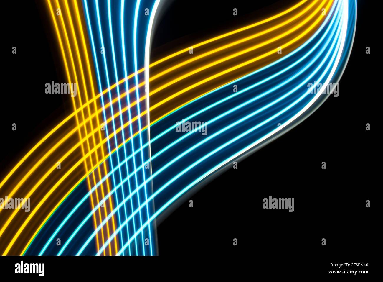Yellow and blue light curve lines on a black background Stock Photo - Alamy