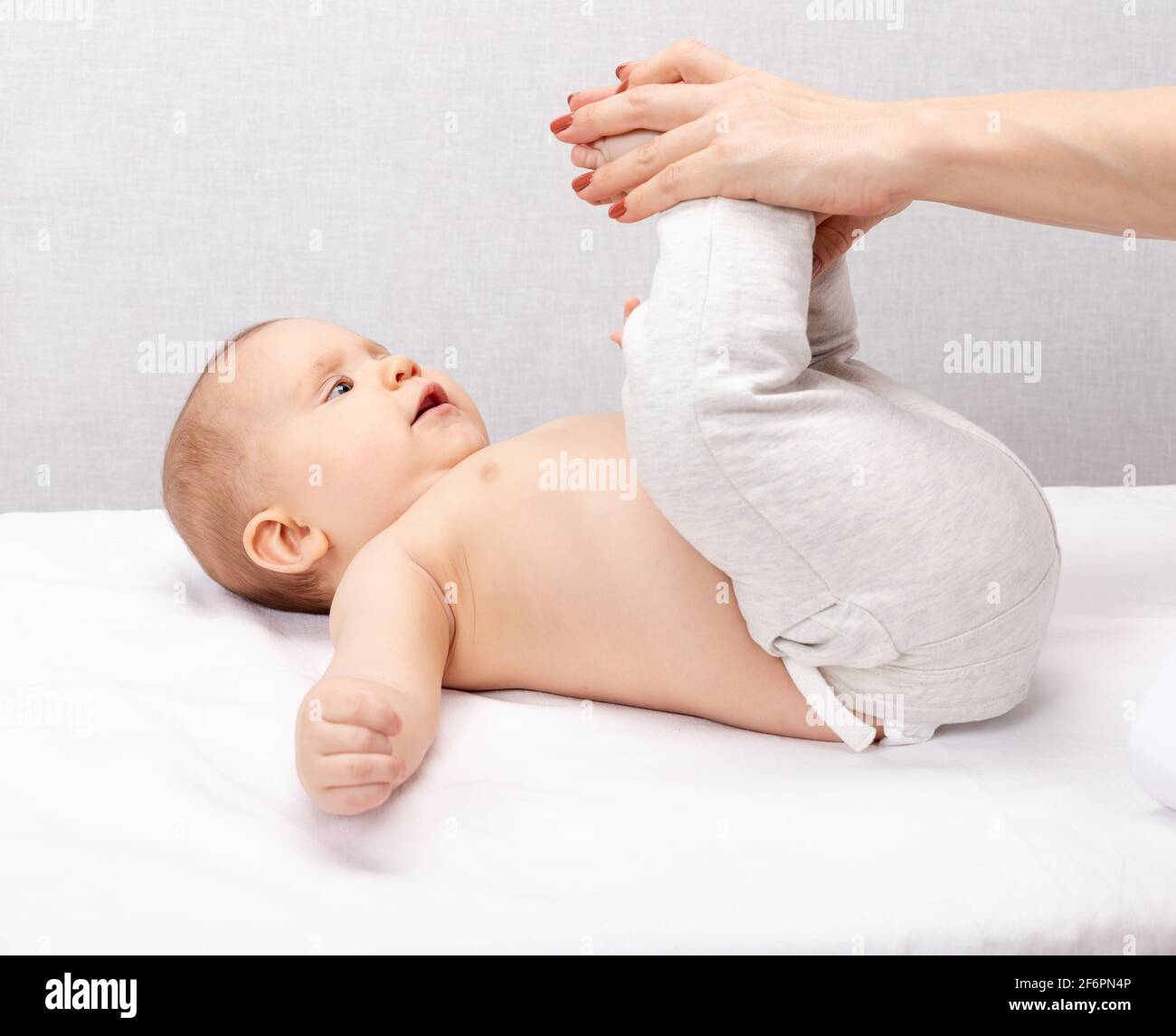 Physiotherapist performing development exercise with six month baby ...