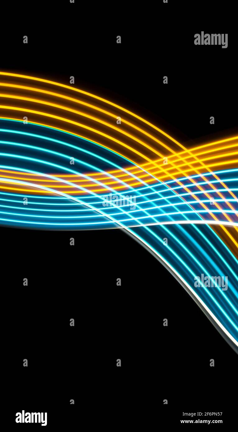 Yellow and blue light curve lines on a black background Stock Photo - Alamy