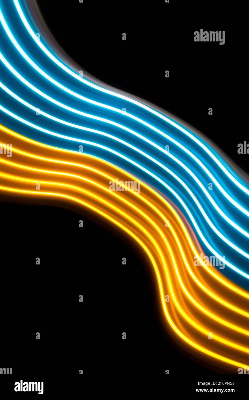 Yellow and blue light curve lines on a black background Stock Photo - Alamy