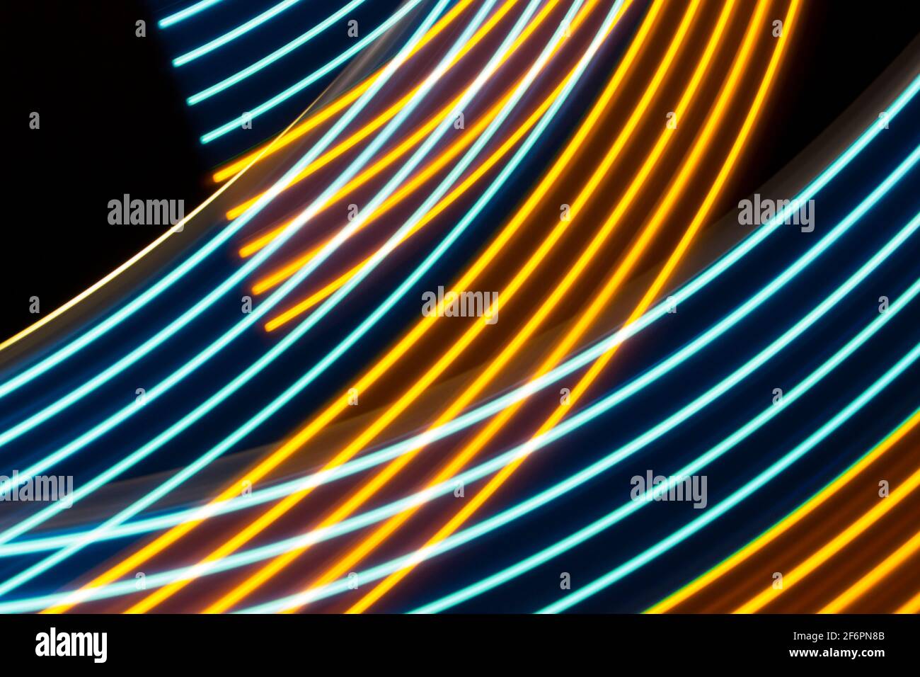 Yellow and blue light curve lines on a black background Stock Photo - Alamy